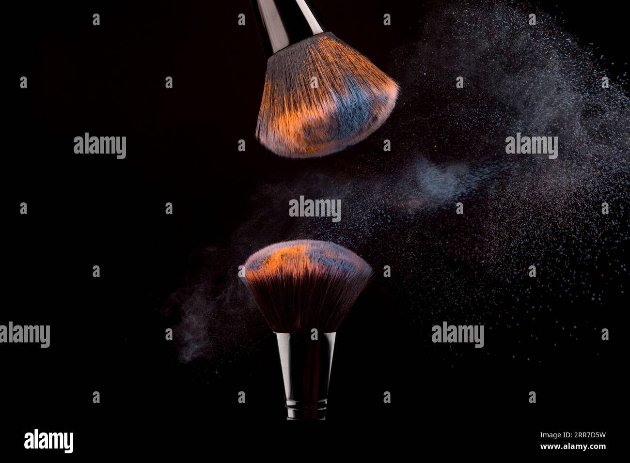 Cosmetic brushes with mist powder dark background Stock Photo - Alamy