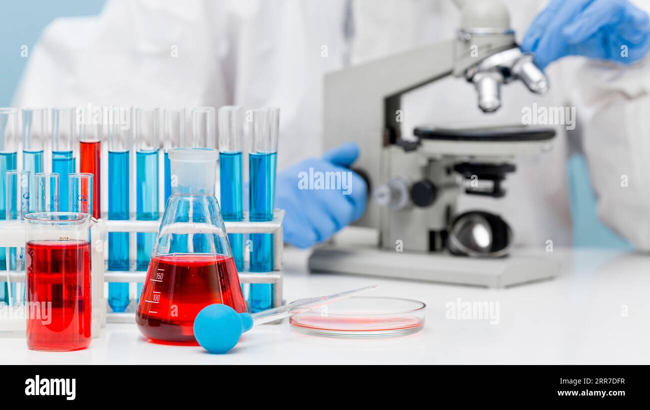 Scientist checking substance with microscope Stock Photo - Alamy