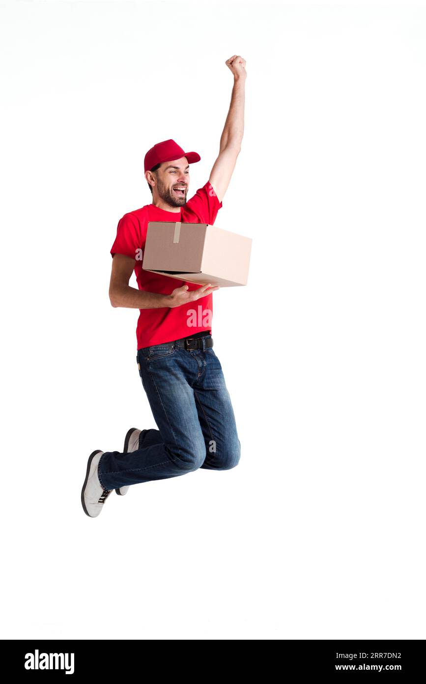 Young delivery man jumping holding box Stock Photo - Alamy