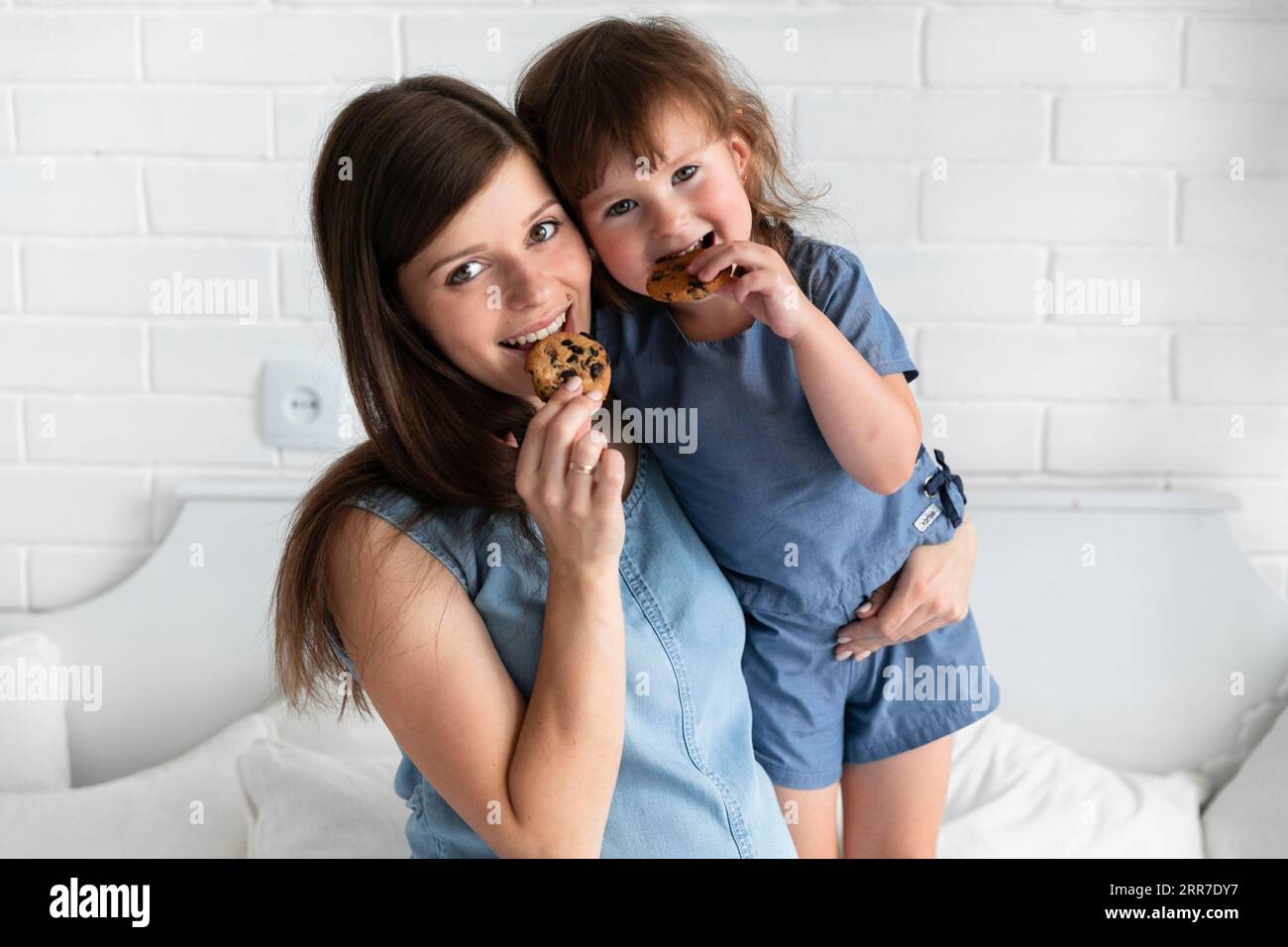 Mother daughter eating chocolate cookies Stock Photo - Alamy