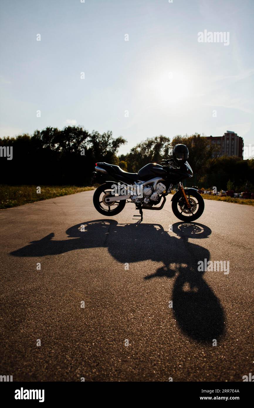 Motorbike sun with shadow Stock Photo - Alamy