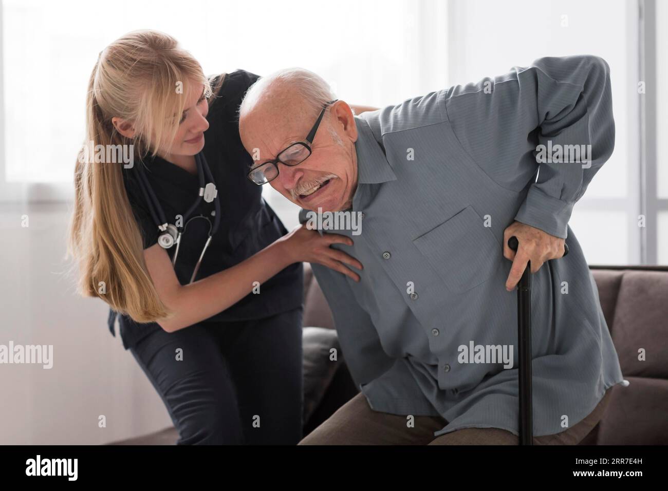 Old man pain helped by nurse Stock Photo - Alamy