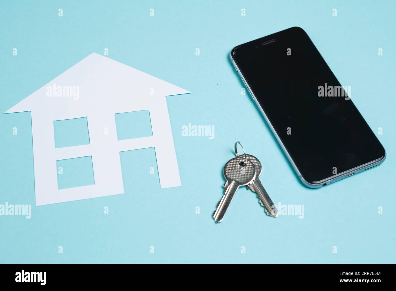 Paper cutout house keys with cellphone blue background Stock Photo - Alamy
