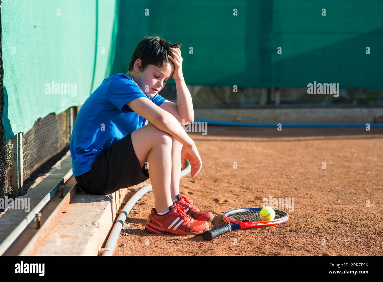 Sideways kid sitting after game Stock Photo - Alamy
