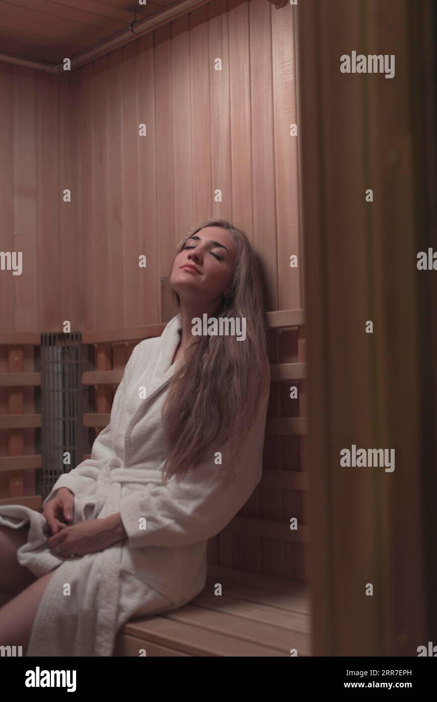 Woman white bathrobe sitting wooden bench relaxing sauna Stock Photo ...