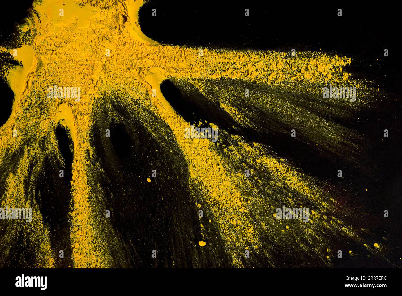 Yellow powder color exploding black backdrop Stock Photo - Alamy