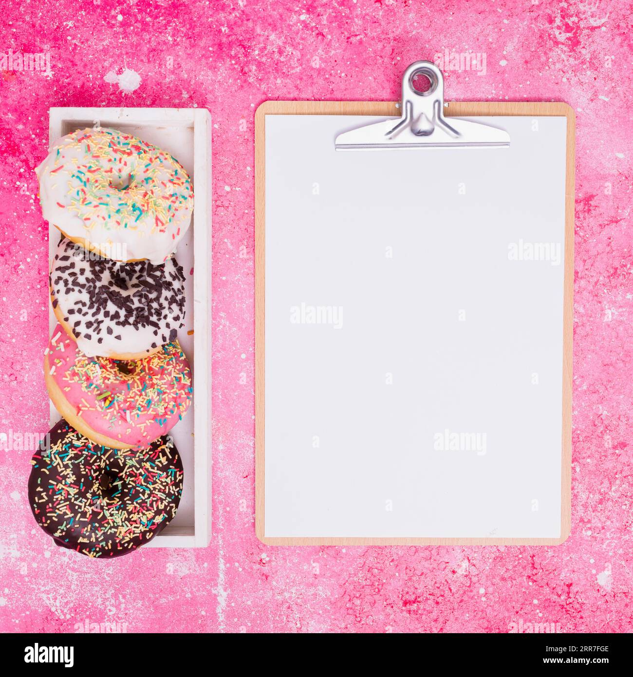 Different type donuts white rectangular box near clipboard with white ...