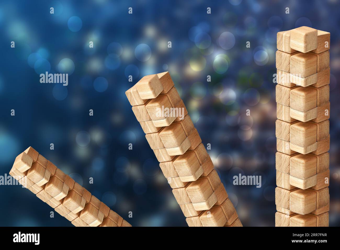 Towers from wooden blocks over abstract blurred blue technology or ...
