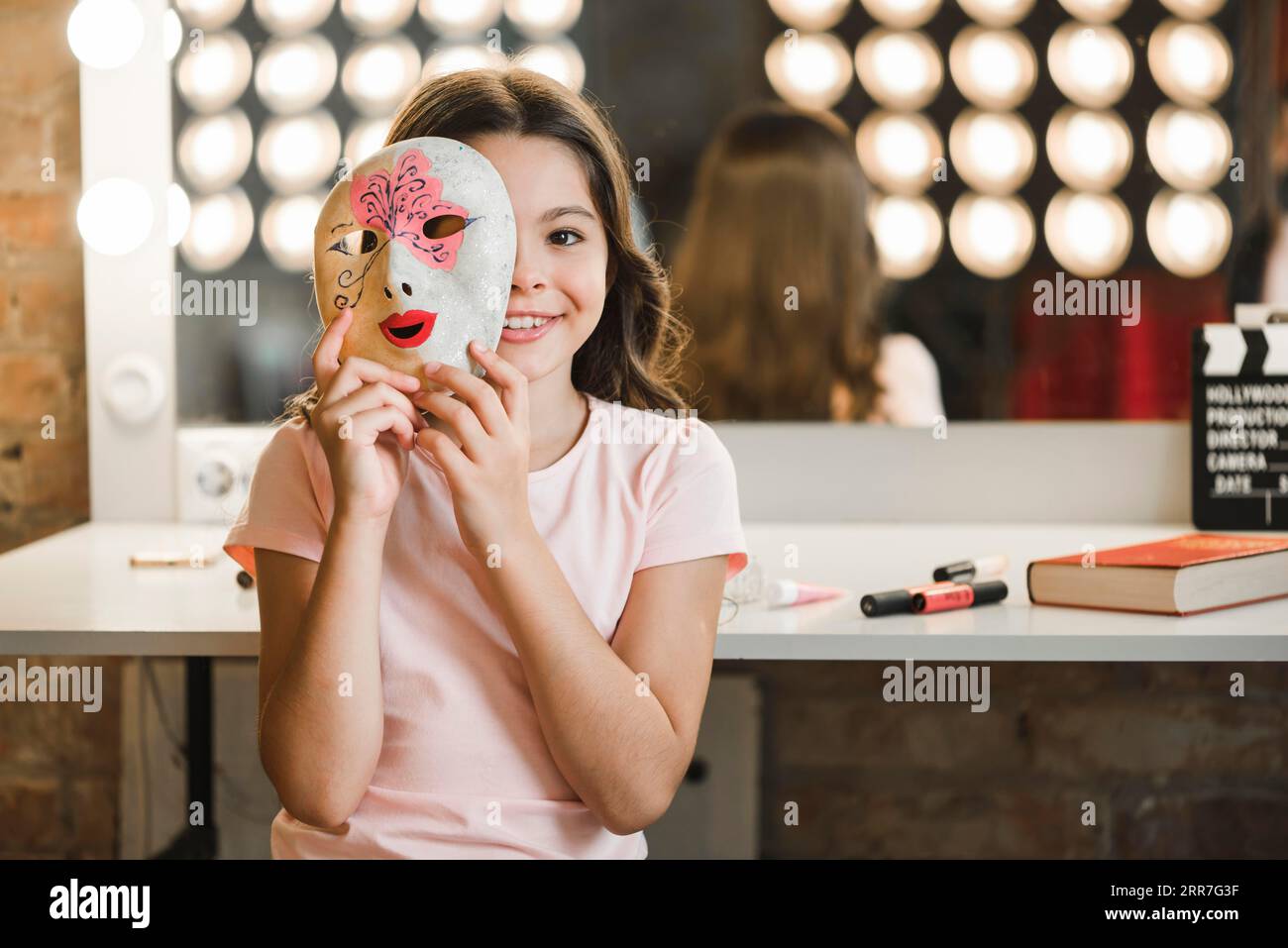 Girl sitting backstage holding venetian mask front her face Stock Photo ...
