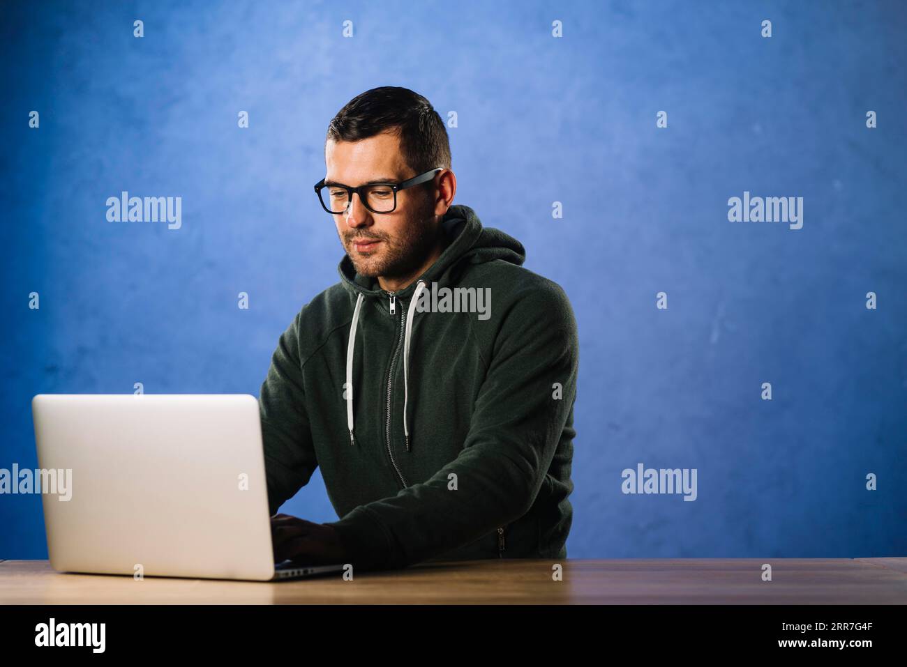 Hacker with glasses looking laptop Stock Photo - Alamy
