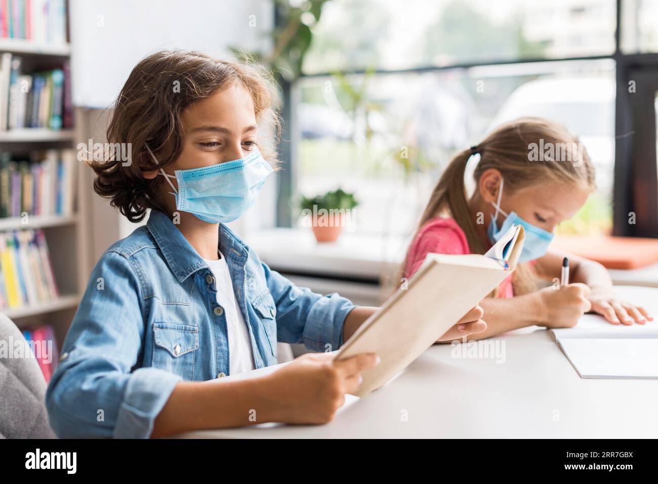 Kids doing their homework while wearing face mask Stock Photo - Alamy