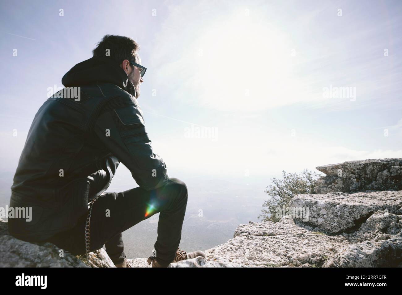 Man sitting rock Stock Photo - Alamy