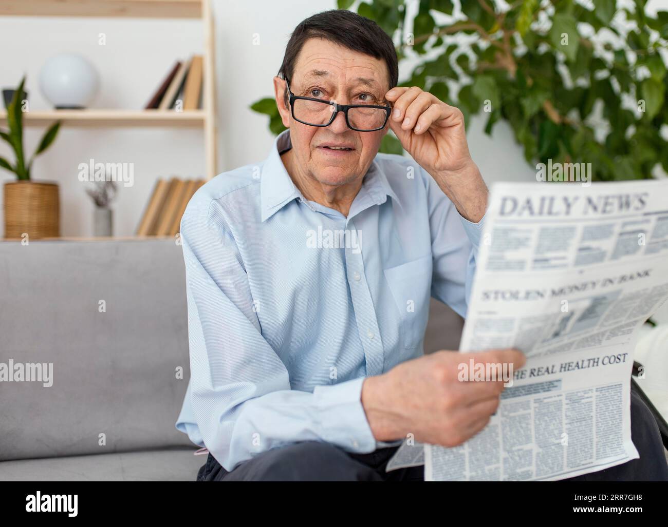 Medium shot man holding newspaper Stock Photo - Alamy