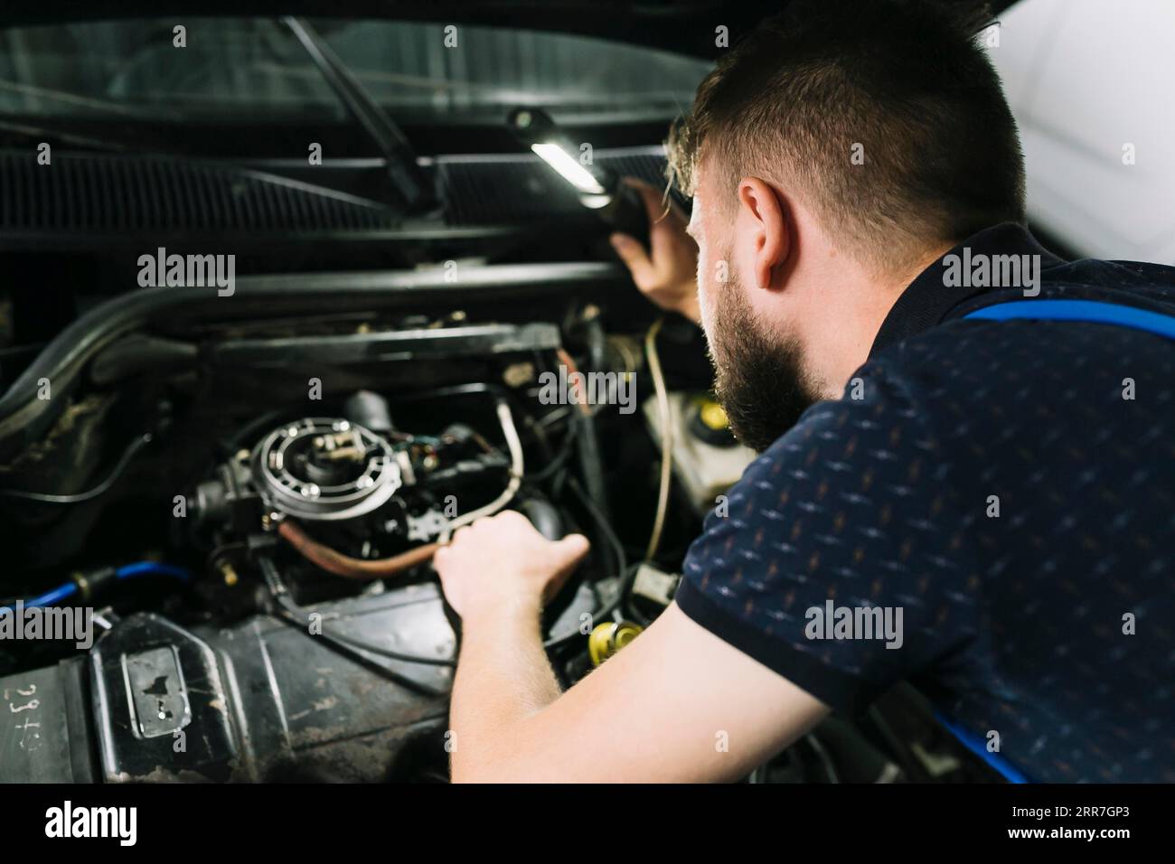 Repairmen inspecting vehicle engine Stock Photo - Alamy