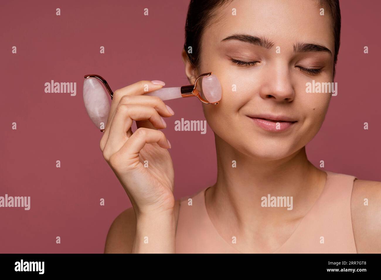 Woman using pink jade roller hi-res stock photography and images - Alamy
