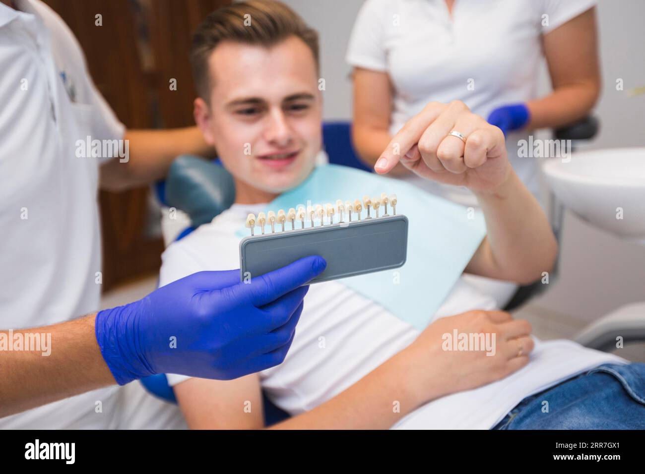 Patient pointing teeth with dentist Stock Photo - Alamy