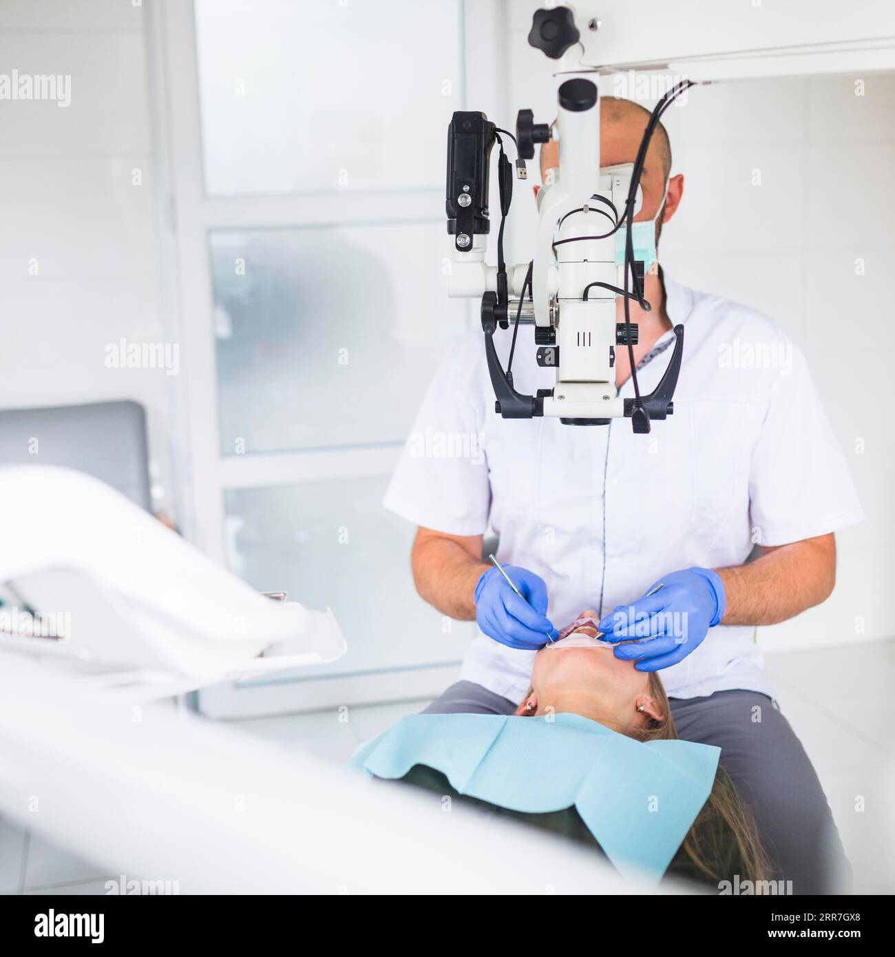 Professional dentist examining patient with dental microscope Stock ...
