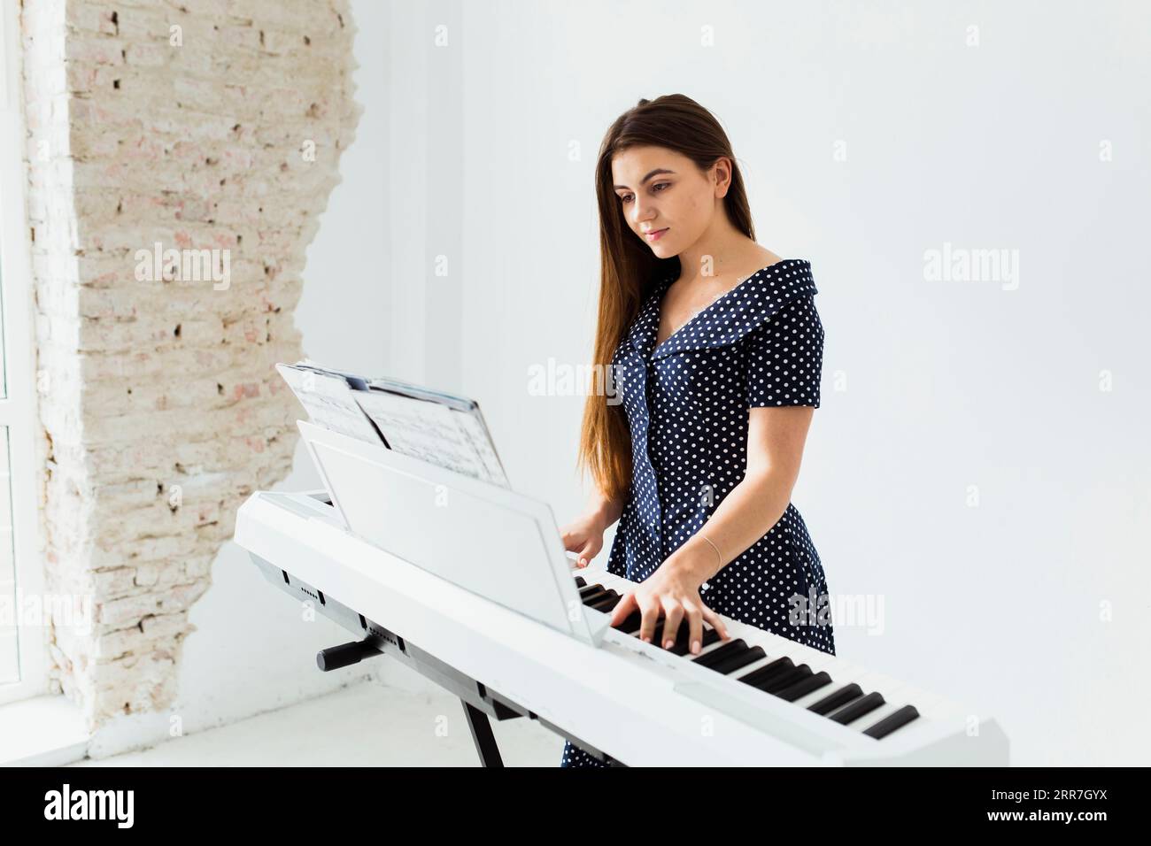 Portrait young woman looking musical sheet playing piano Stock Photo ...