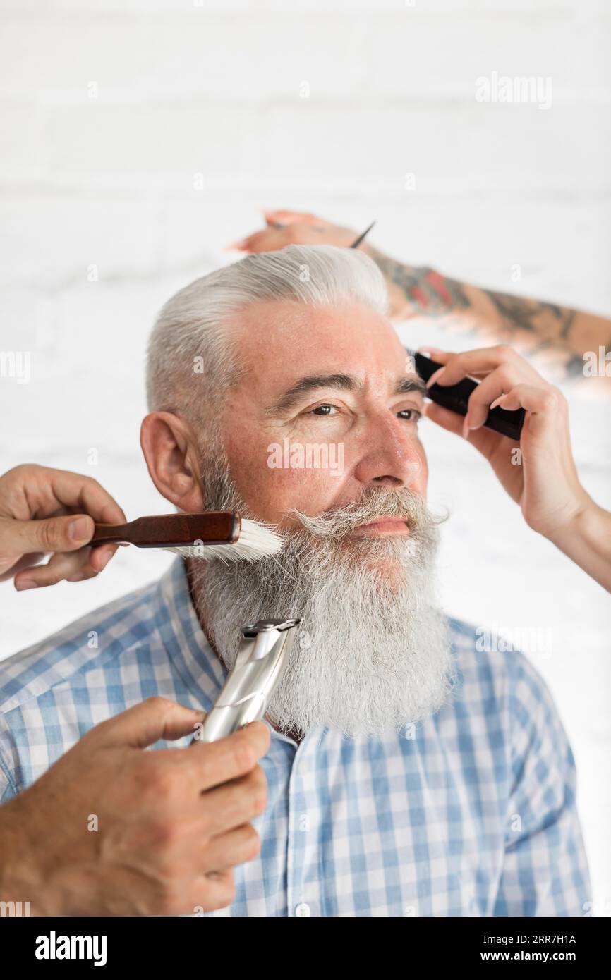 Senior customer getting beard hair care Stock Photo - Alamy