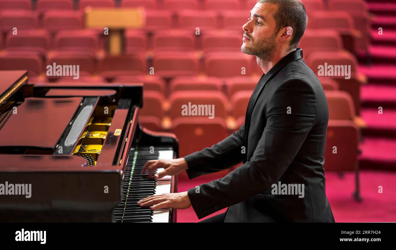 Side view man playing classical piano recital Stock Photo - Alamy