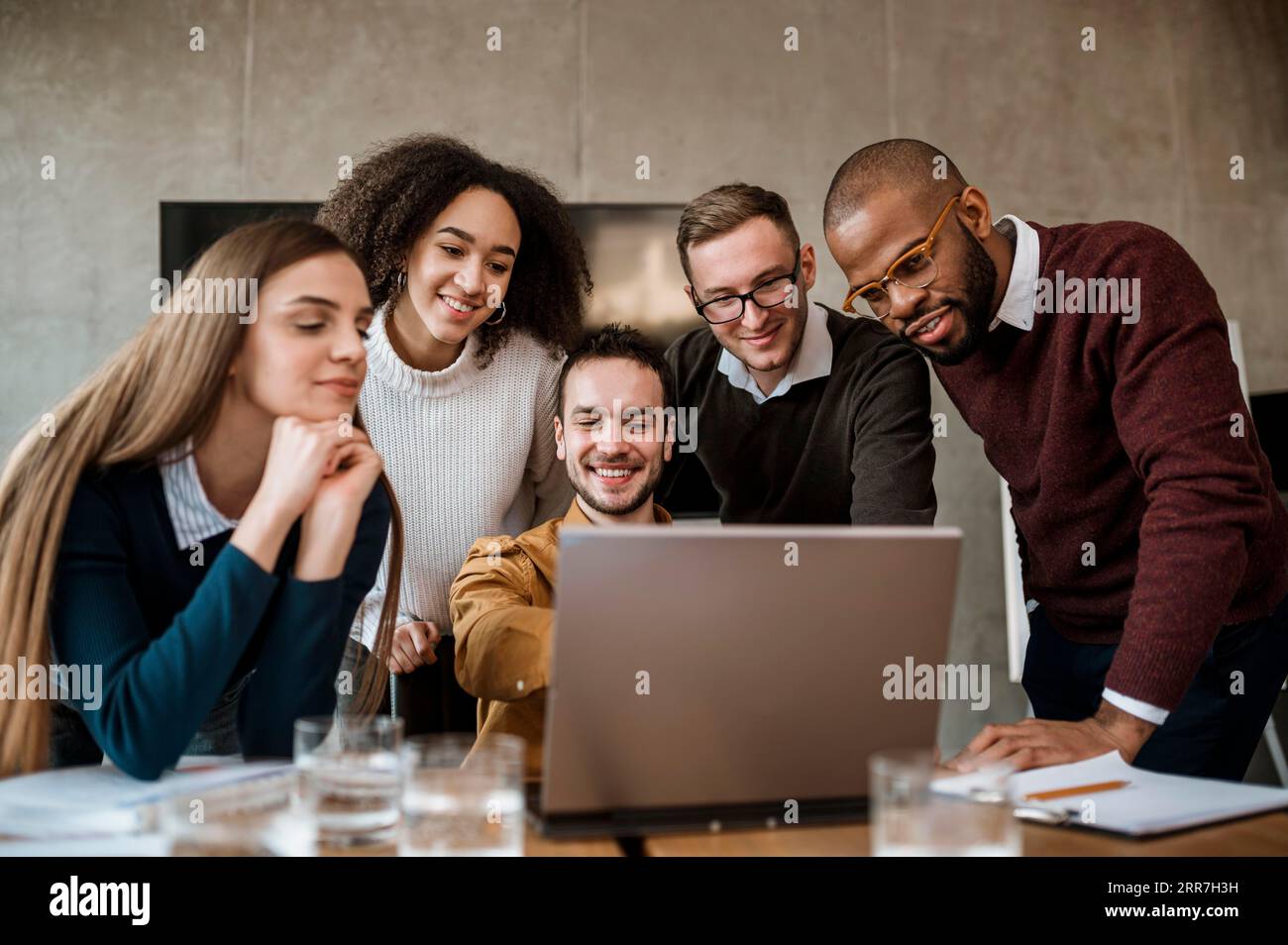 Smiley man showing something his colleagues laptop during meeting Stock ...