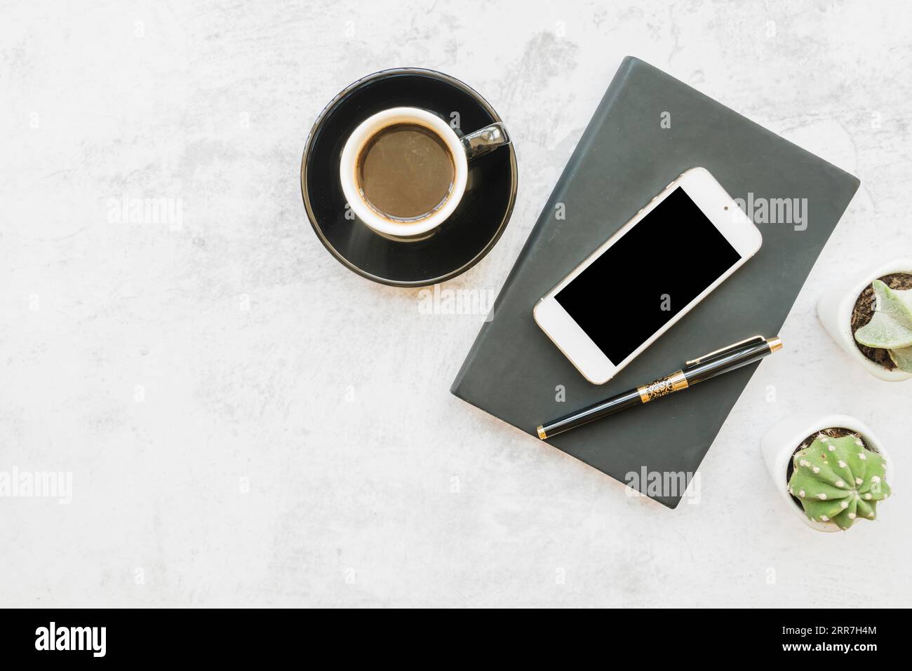 Smartphone coffee table with notebook Stock Photo - Alamy