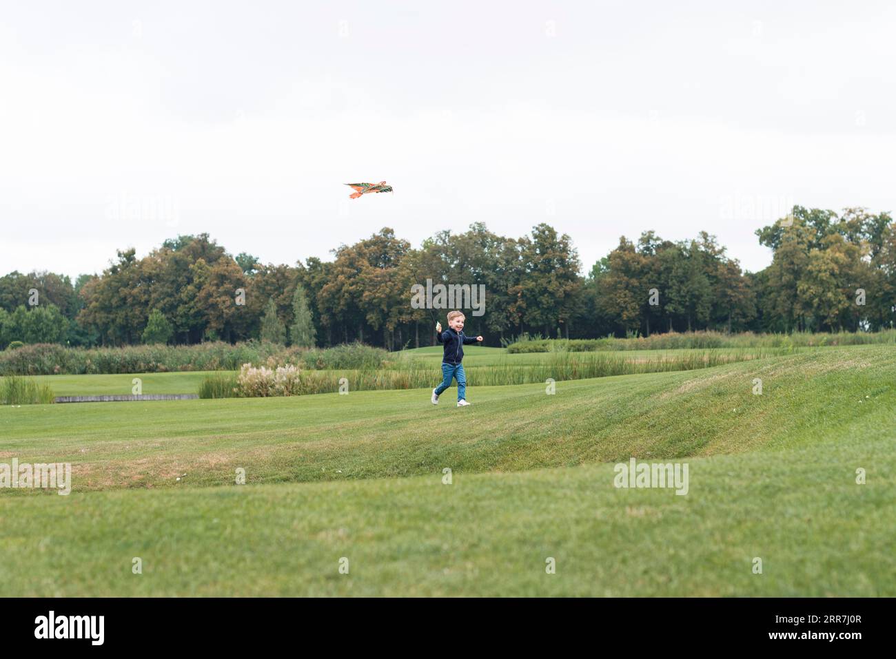 Boy playing with kite long shot Stock Photo - Alamy