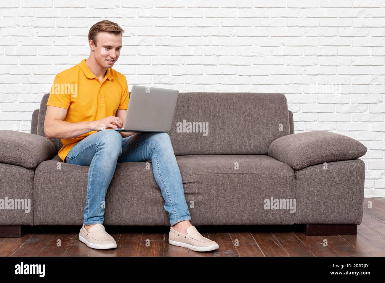 Front view man sitting while checking laptop Stock Photo - Alamy