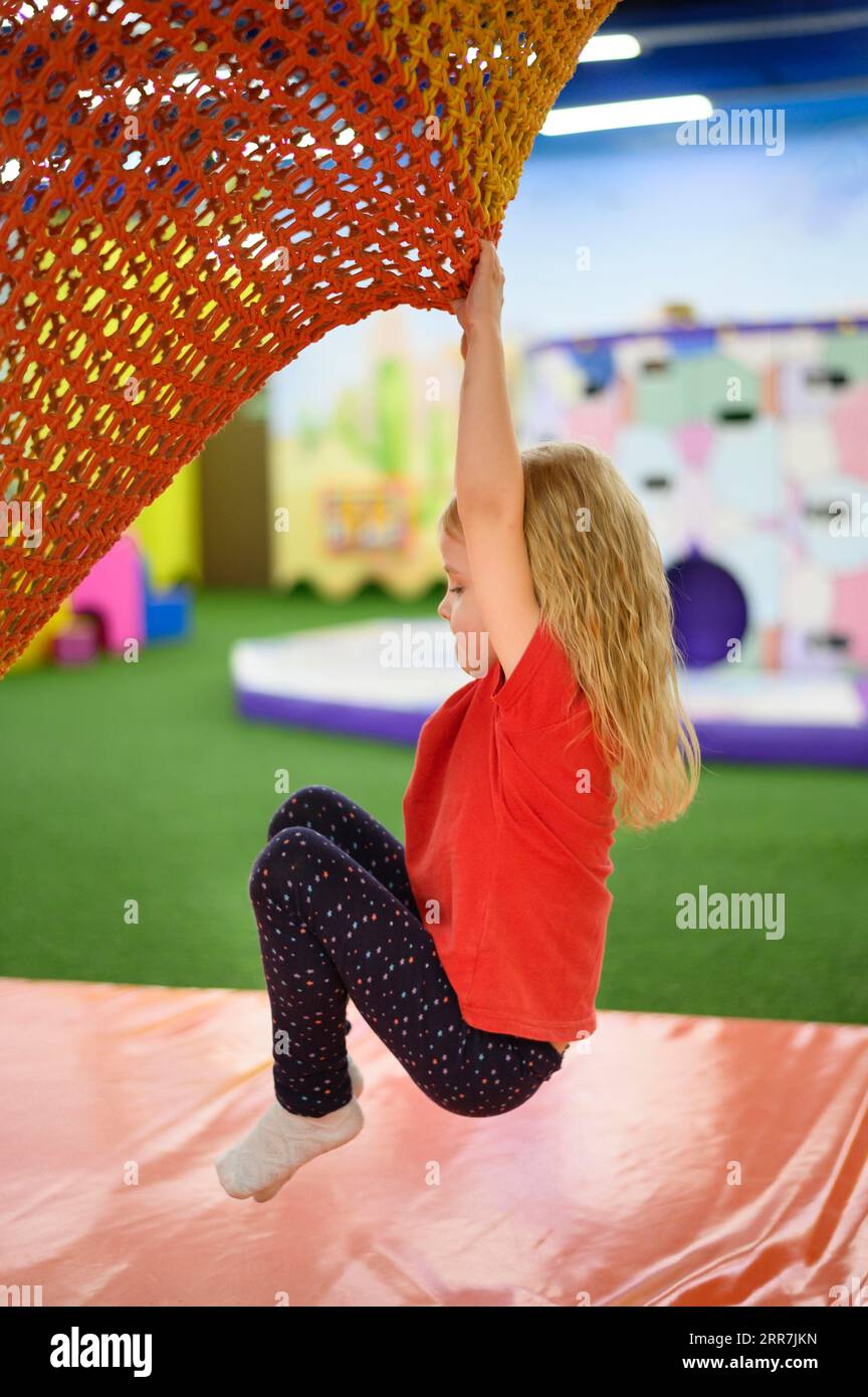 Girl climbing playground side view Stock Photo - Alamy