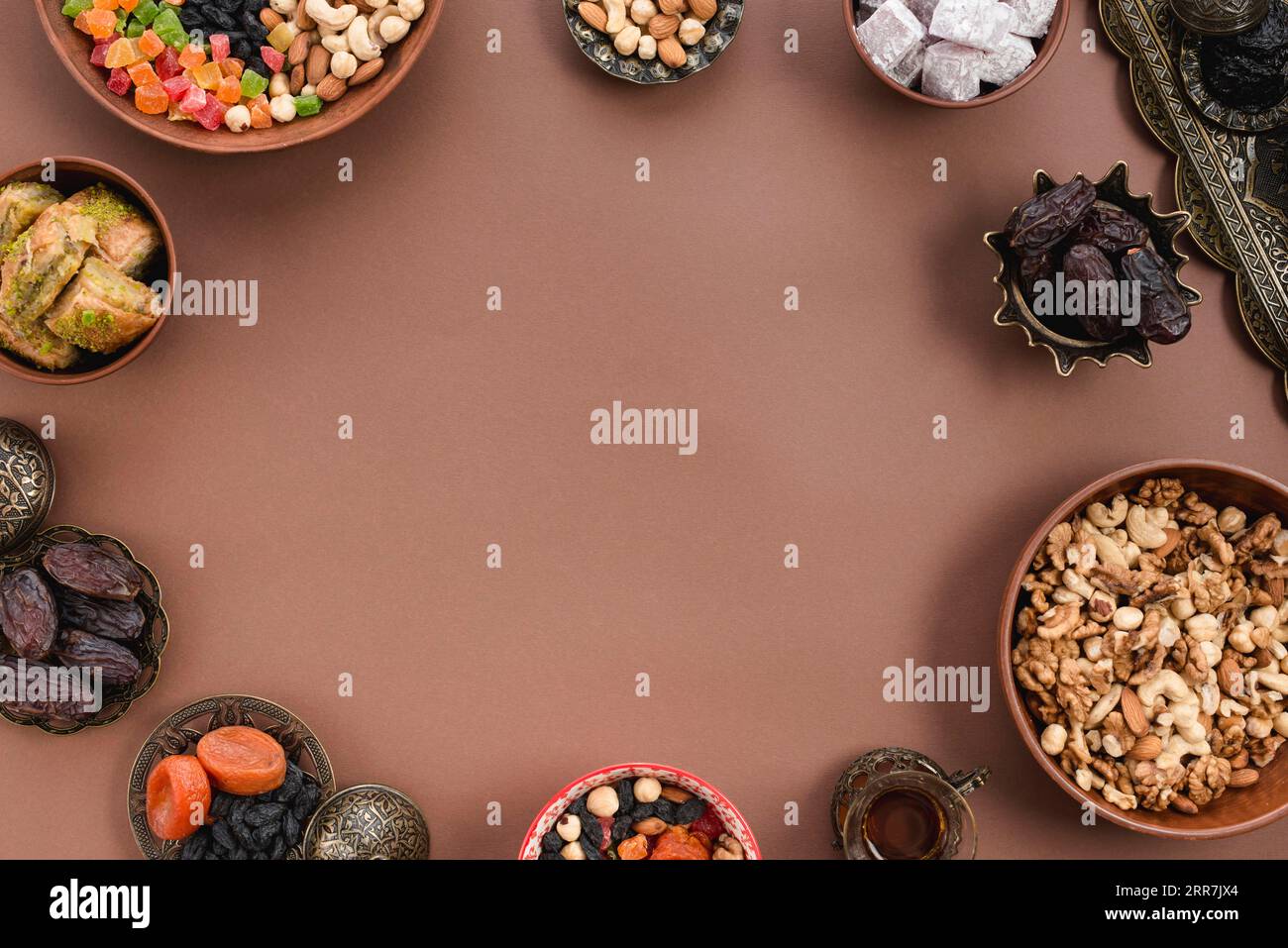 Metallic earthen bowl dried fruits dates lukum nuts baklava arranged ...
