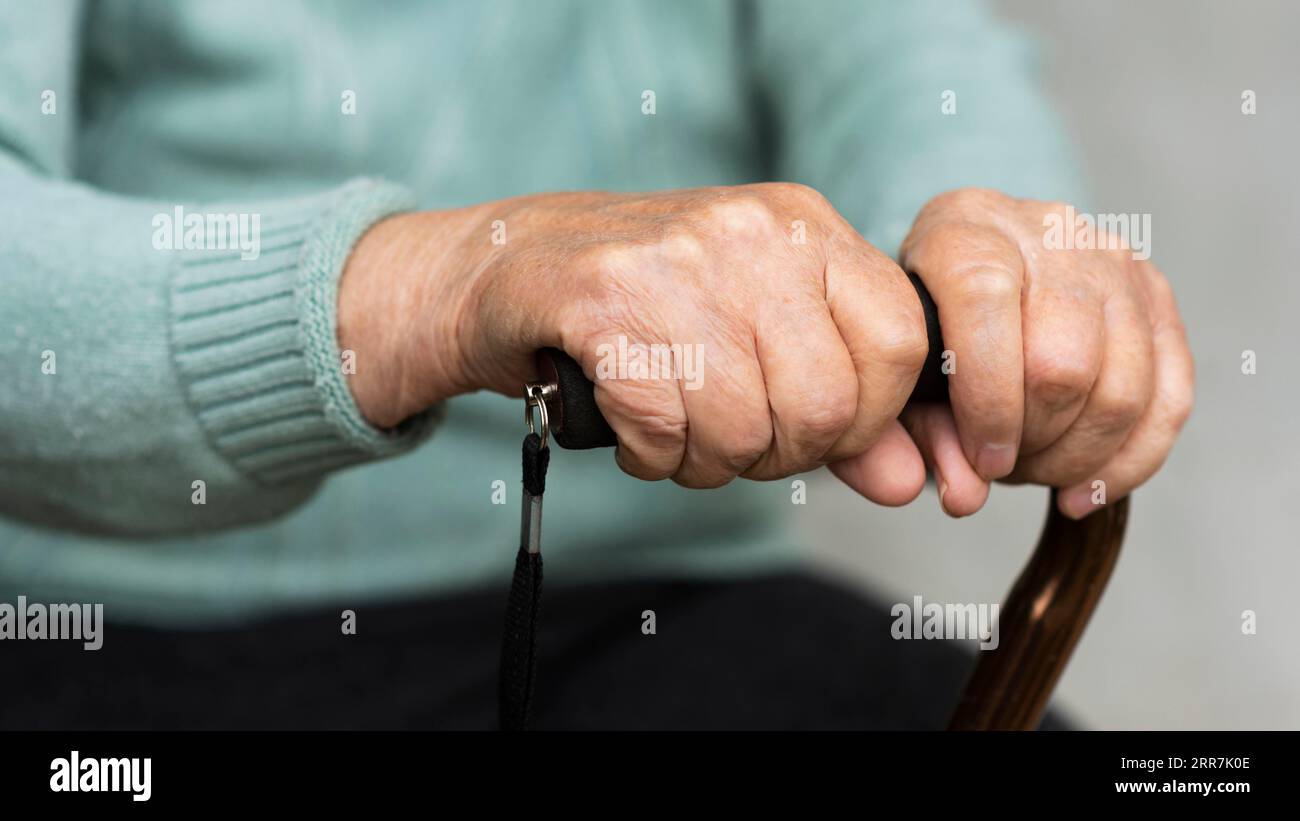 Older woman holding cane hands Stock Photo - Alamy