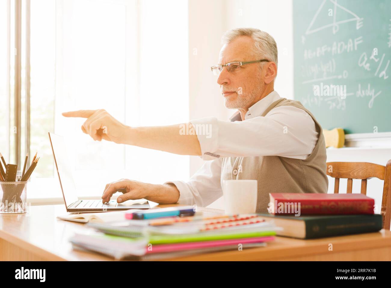 Old teacher pointing classroom Stock Photo - Alamy