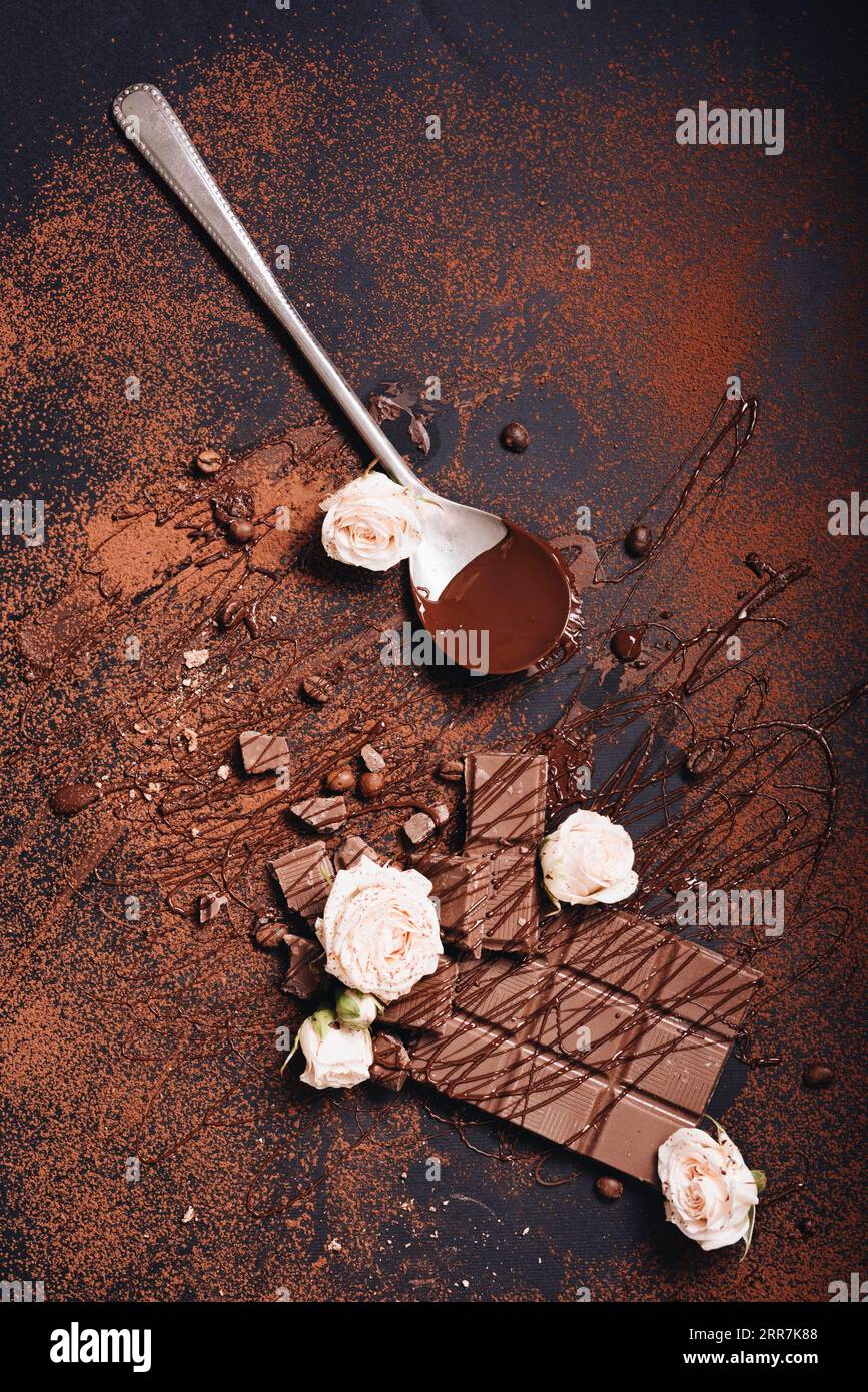 Pink roses with chocolate bar syrup dark textured background Stock ...