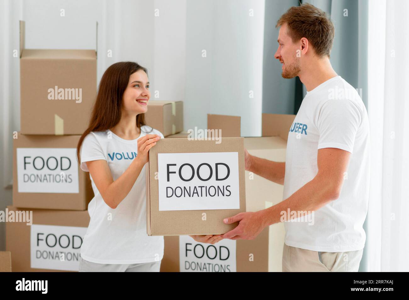 Side view volunteers handling boxes with food donations Stock Photo - Alamy