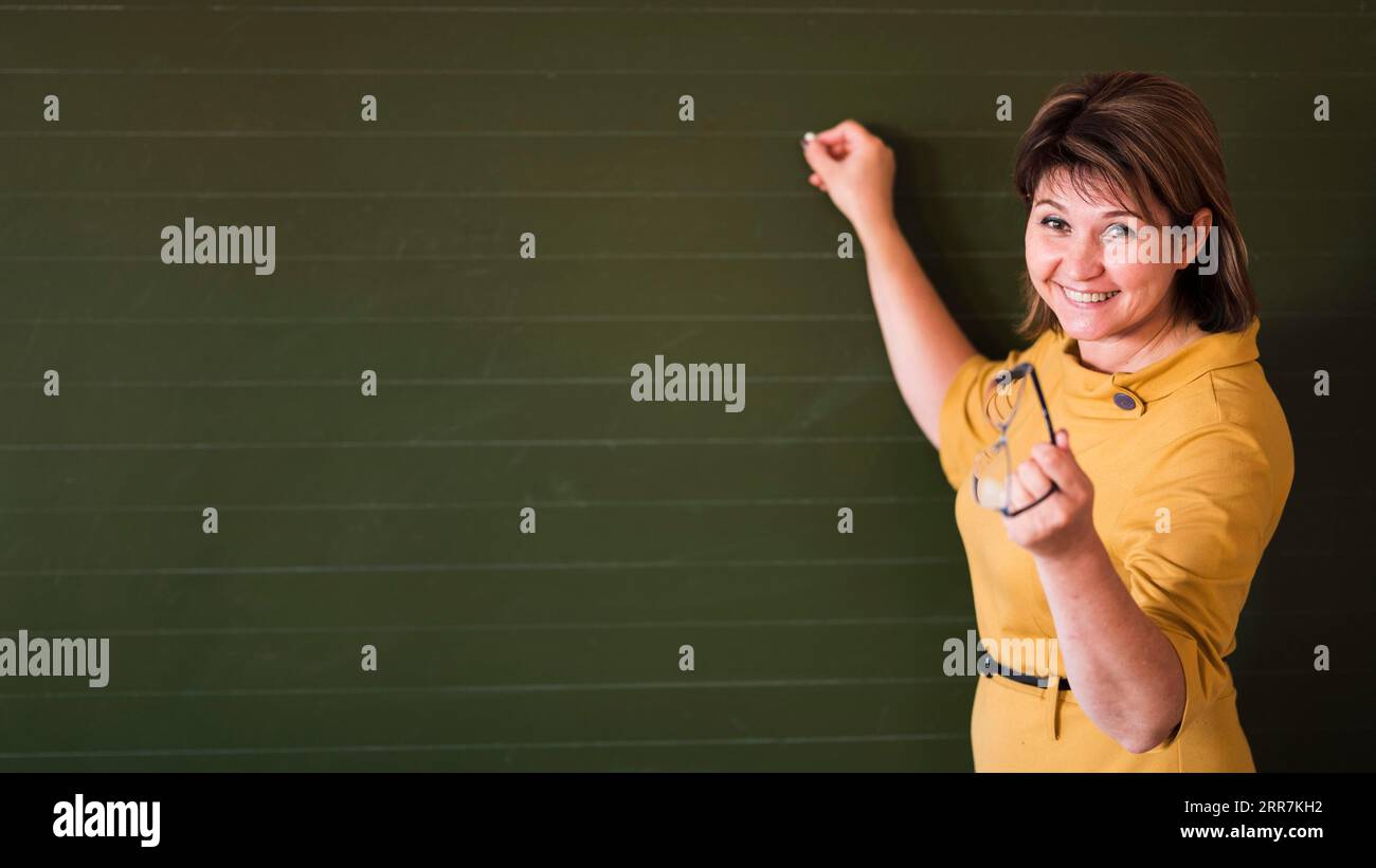 Teacher pointing chalkboard with copy space Stock Photo - Alamy