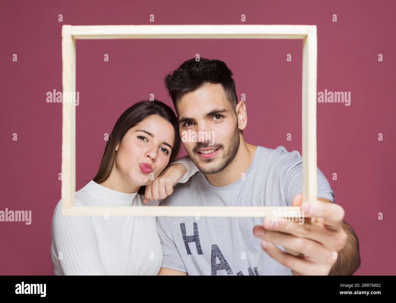 Young lady with hand shoulder positive guy holding frame Stock Photo ...