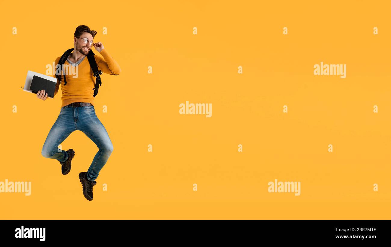 Young man with book jumping Stock Photo - Alamy