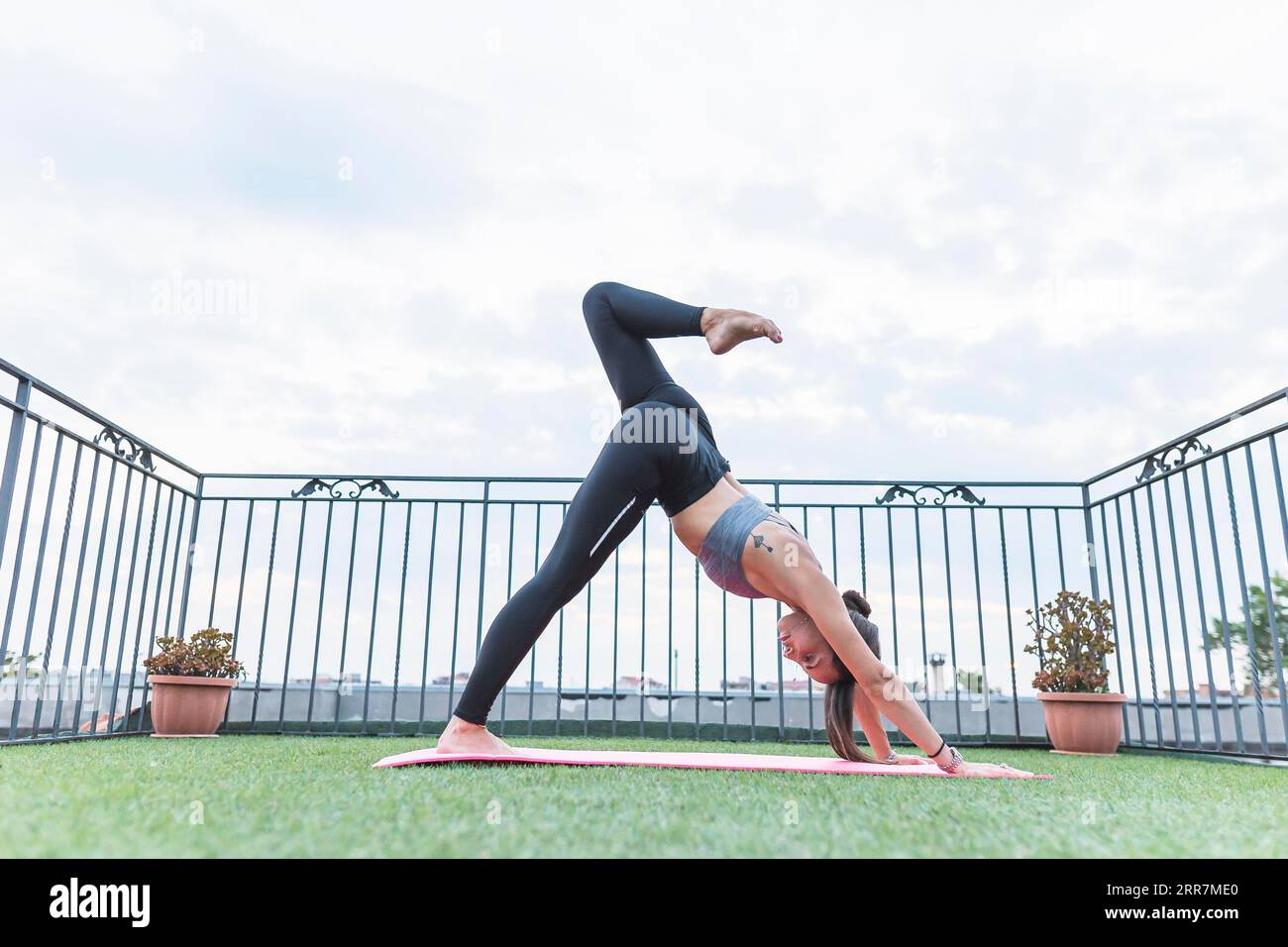 Fitness young woman doing exercise balcony turf Stock Photo - Alamy