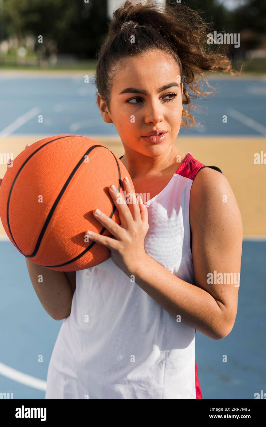 Front view girl holding basketball ball Stock Photo - Alamy