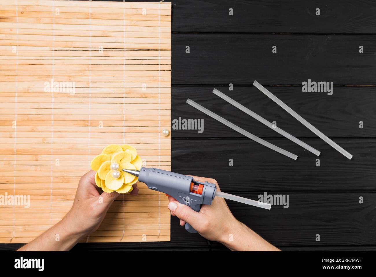 Human hand sticking bead yellow flower with hot glue gun Stock Photo ...