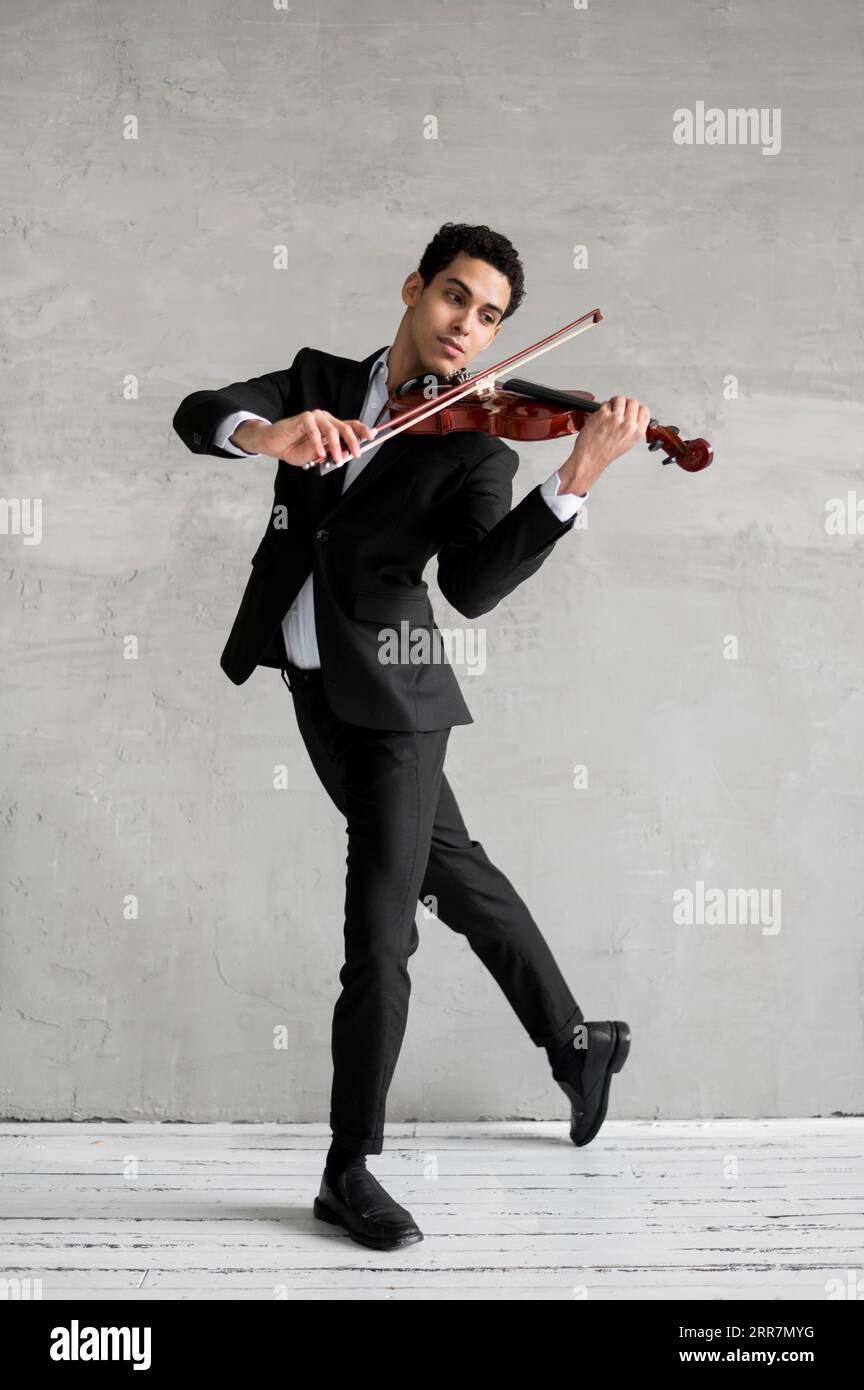 Male musician dancing playing violin Stock Photo - Alamy