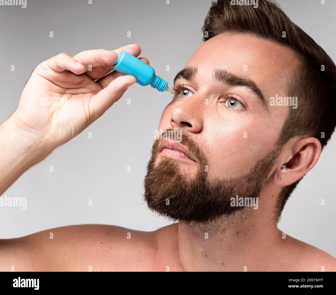 Man using eye drops Stock Photo - Alamy
