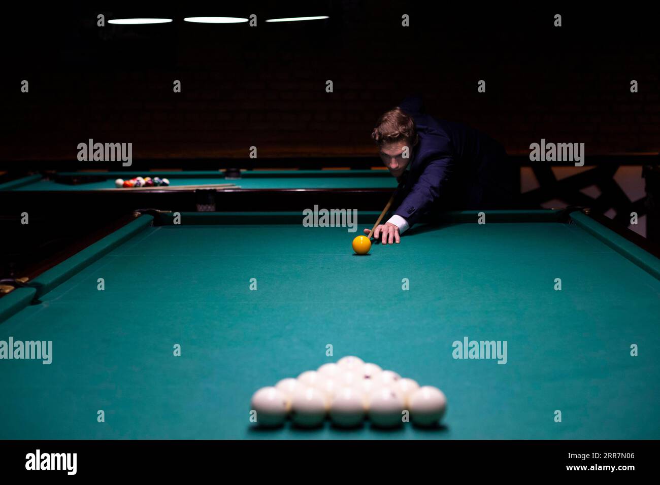 Medium shot man suit playing billiard Stock Photo - Alamy