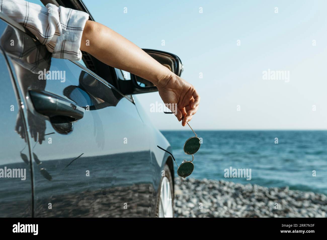 Mid shot woman hand hanging out car window near sea Stock Photo - Alamy