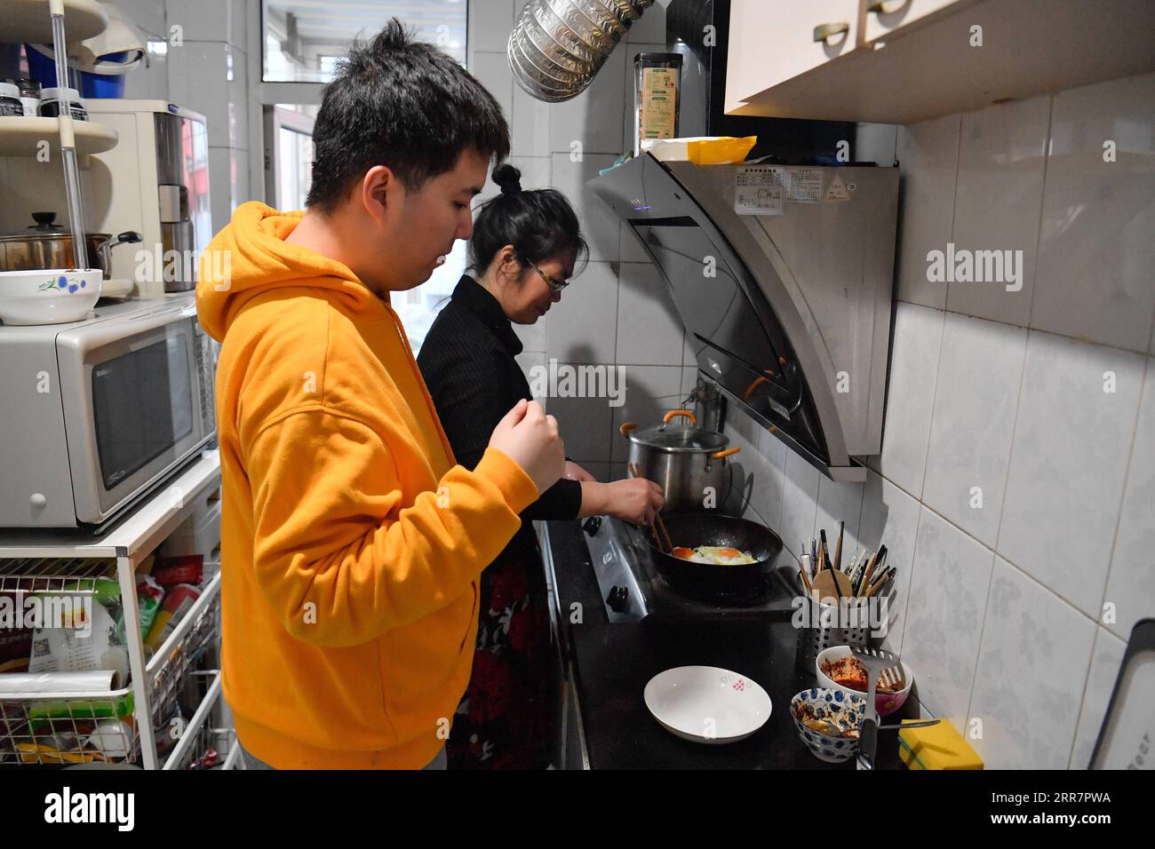 210402 -- TIANJIN, April 2, 2021 -- Wu Guixiang helps her son Zhang Hao ...