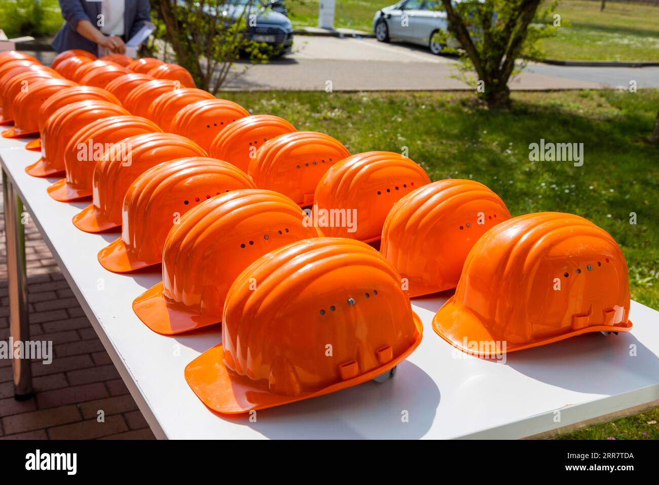 Orange-coloured safety helmets are on display for a factory tour Stock ...