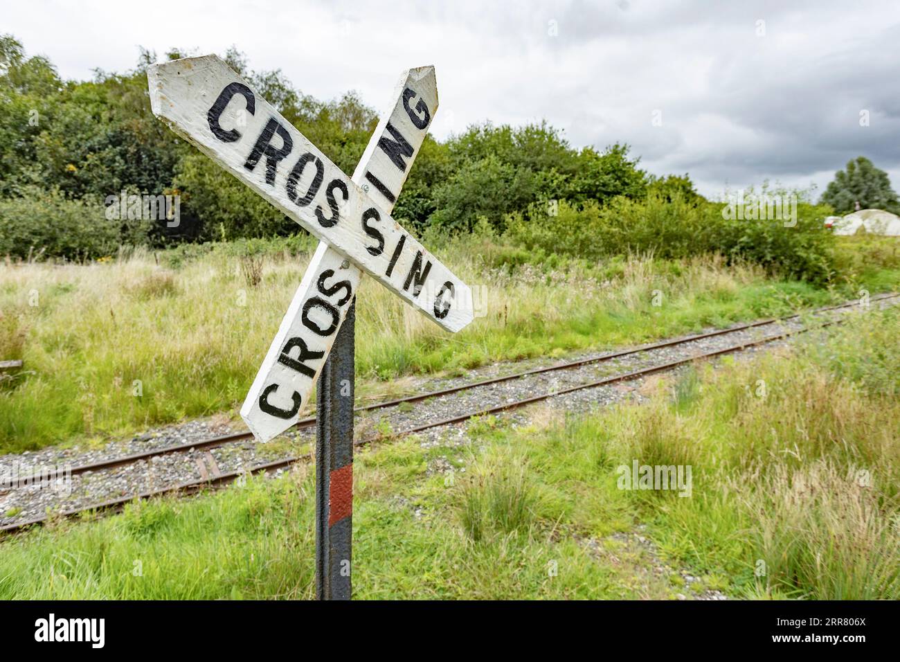 "cross road" portion of sign with railroad tracks in background ...
