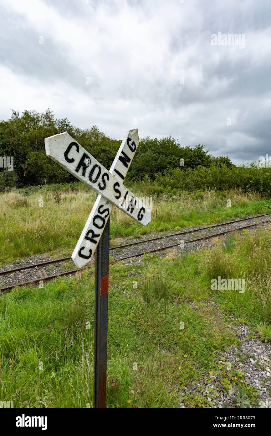 "cross road" portion of sign with railroad tracks in background ...