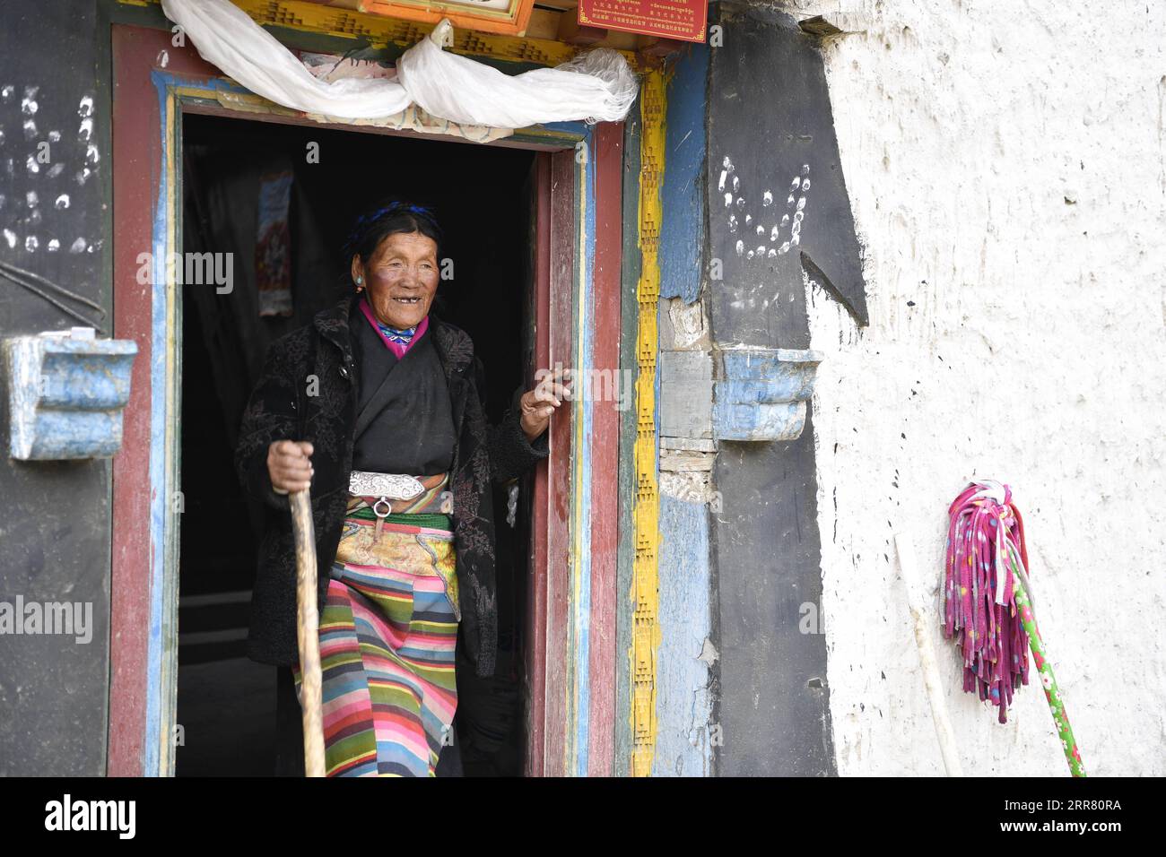 210411 -- XIGAZE, April 11, 2021 -- Lhapa stands at a door of her house ...