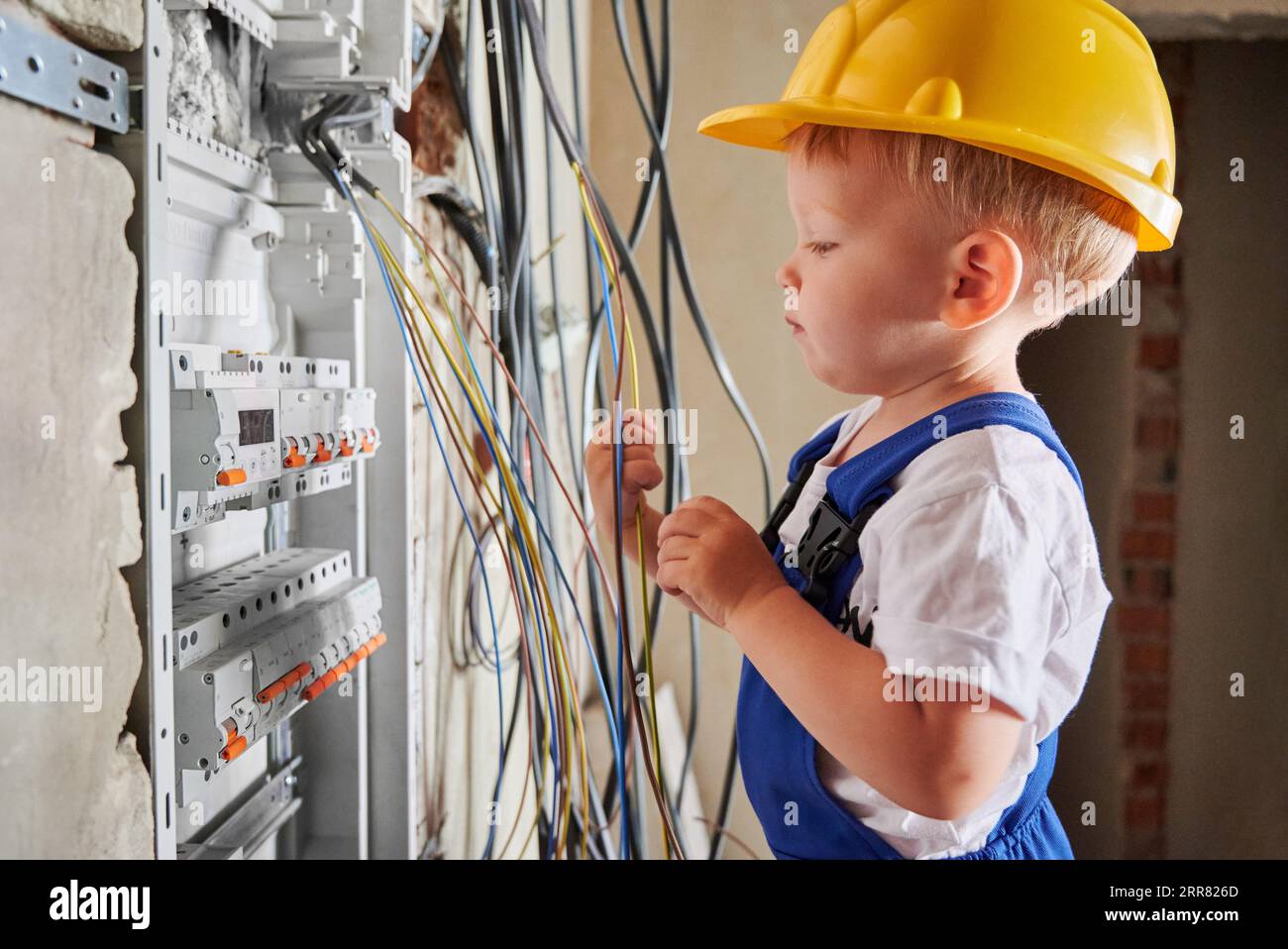 Little boy electrician playing with electrical wires while repairing ...